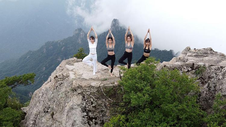 Yoga enthusiasts perform on cliffs in central China - CGTN