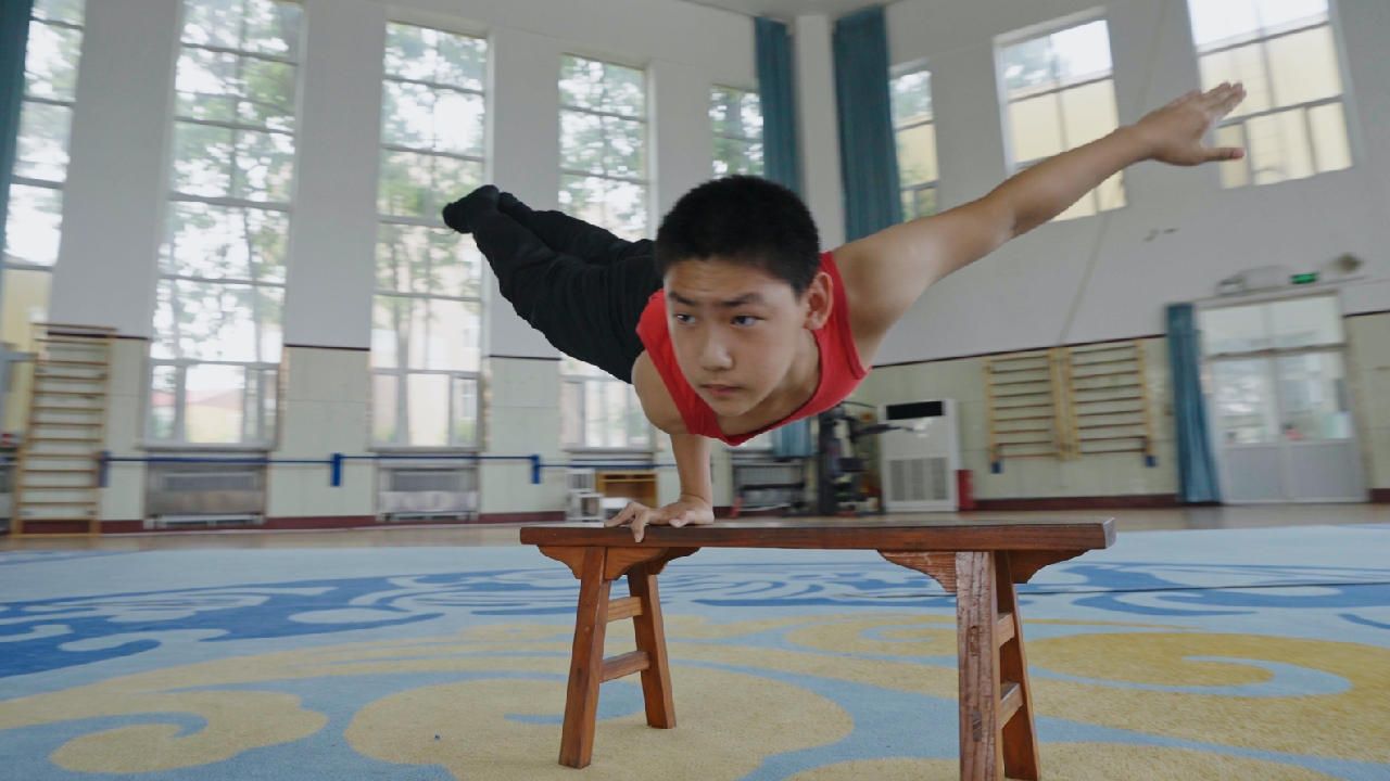 How a young slack-wire walker performs his difficult balancing act - CGTN