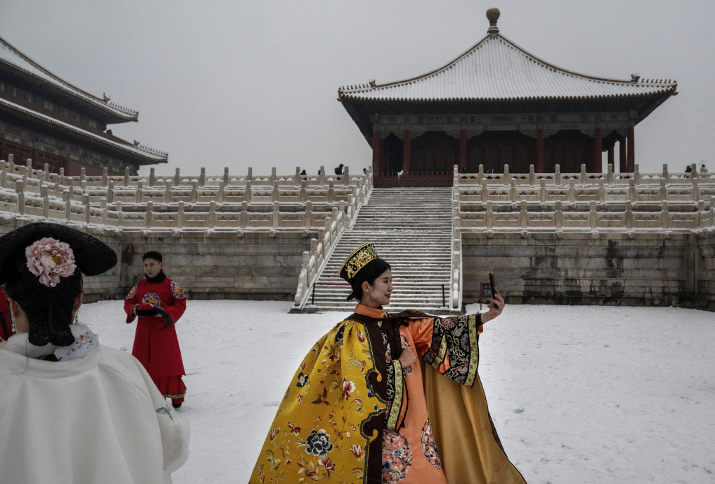 Visitors strike poses in hanfu at Beijing's Forbidden City amid snow - CGTN